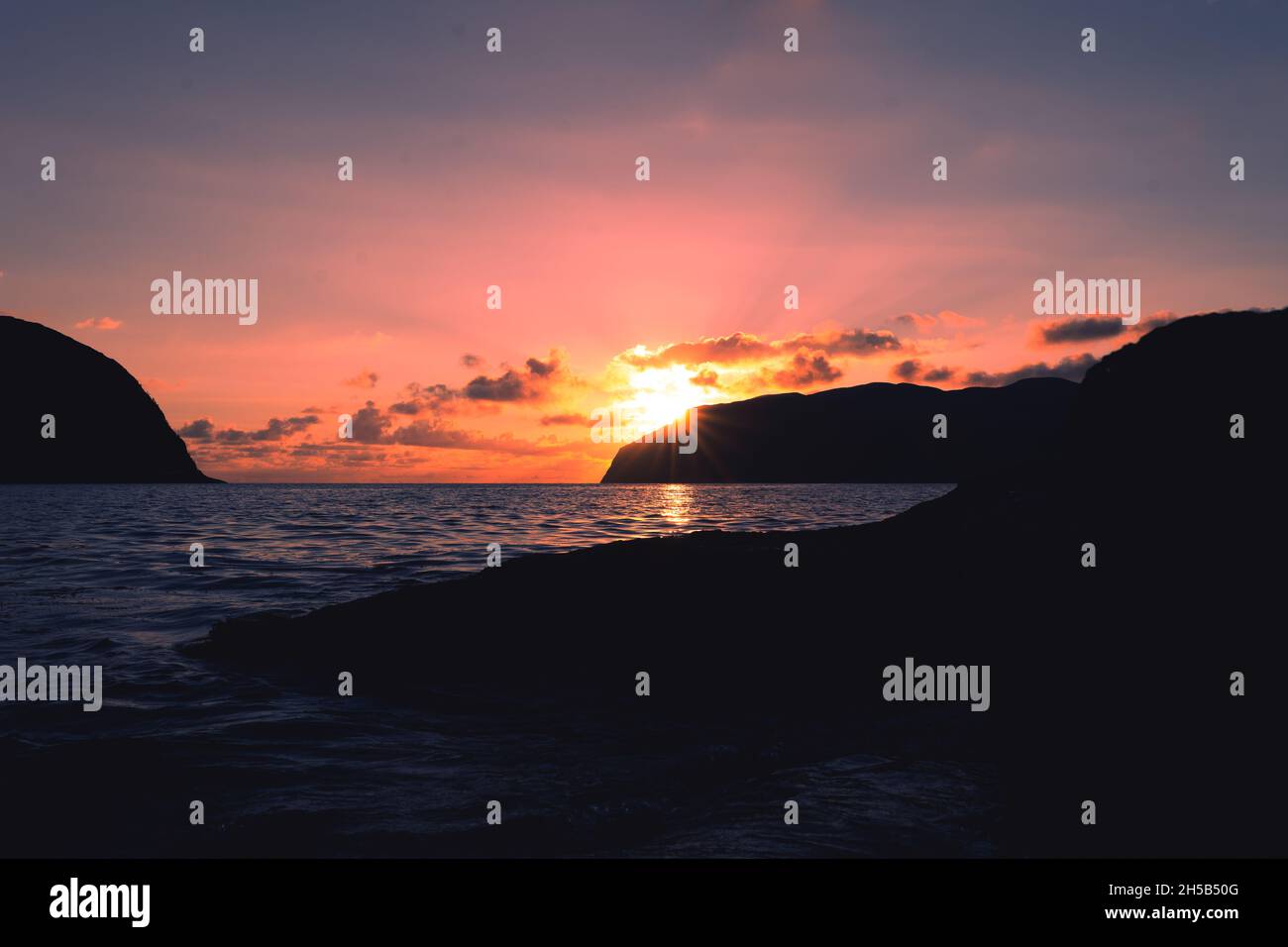 Landscape of cliffs surrounded by the sea during a breathtaking sunrise ...