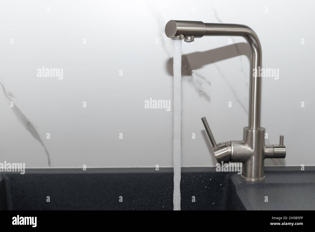 Modern kitchen tap with flowing water Stock Photo - Alamy