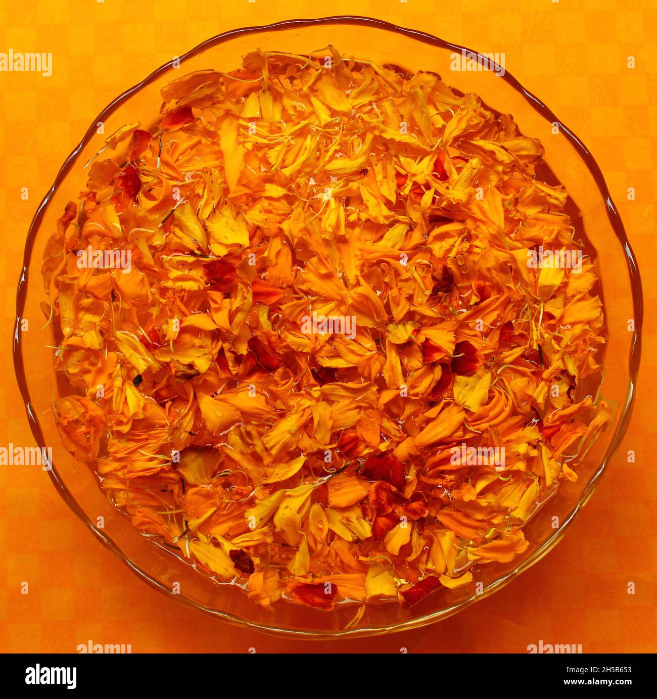 Closeup of Marigold flower petals in a transparent glass bowl filled ...