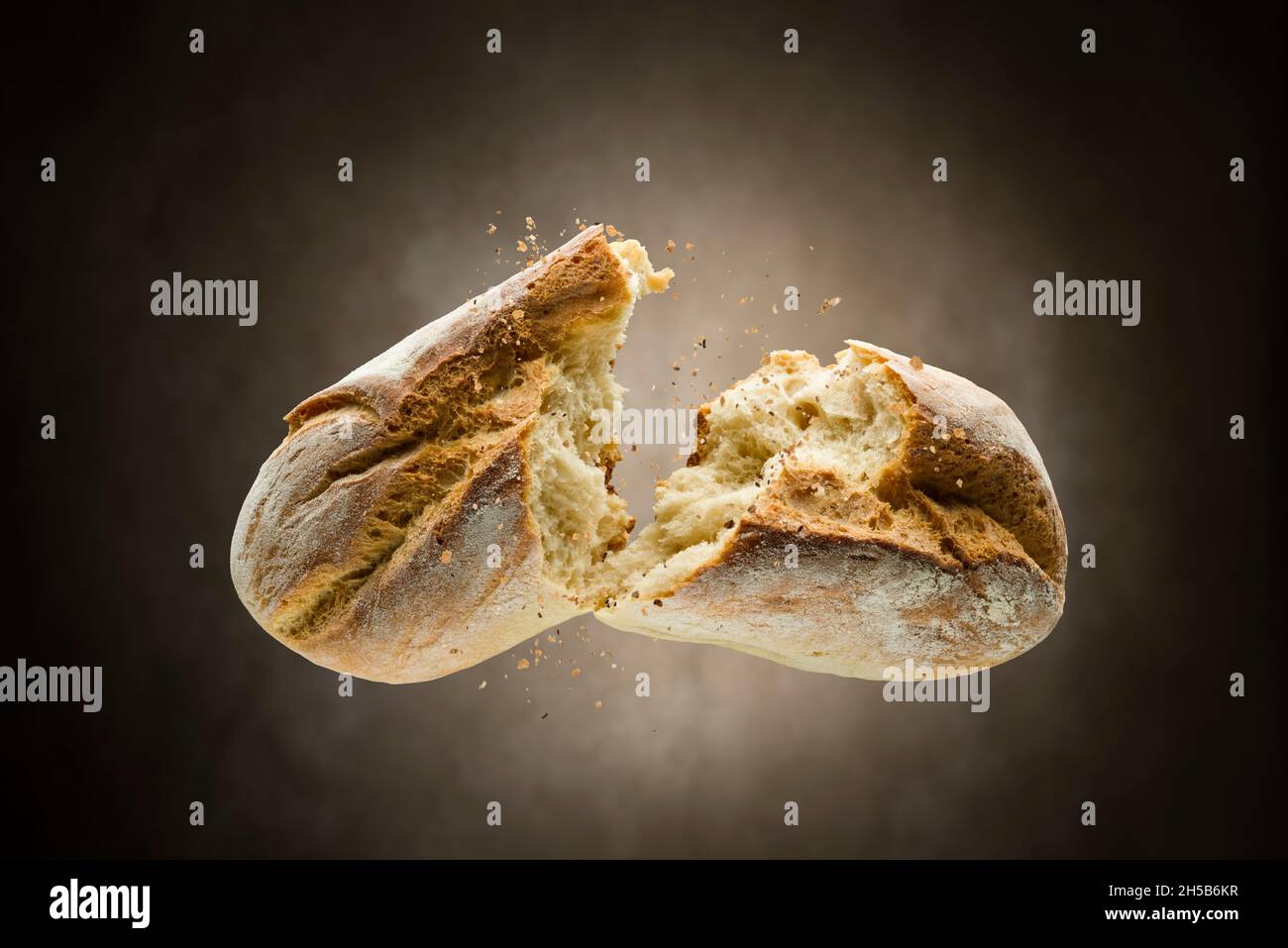 Fresh crunchy baked bread opened on brown background Stock Photo - Alamy