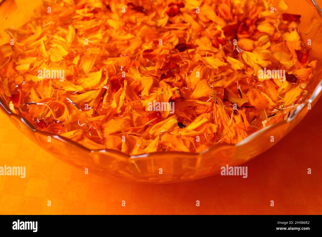 Closeup of Marigold flower petals in a transparent glass bowl filled ...