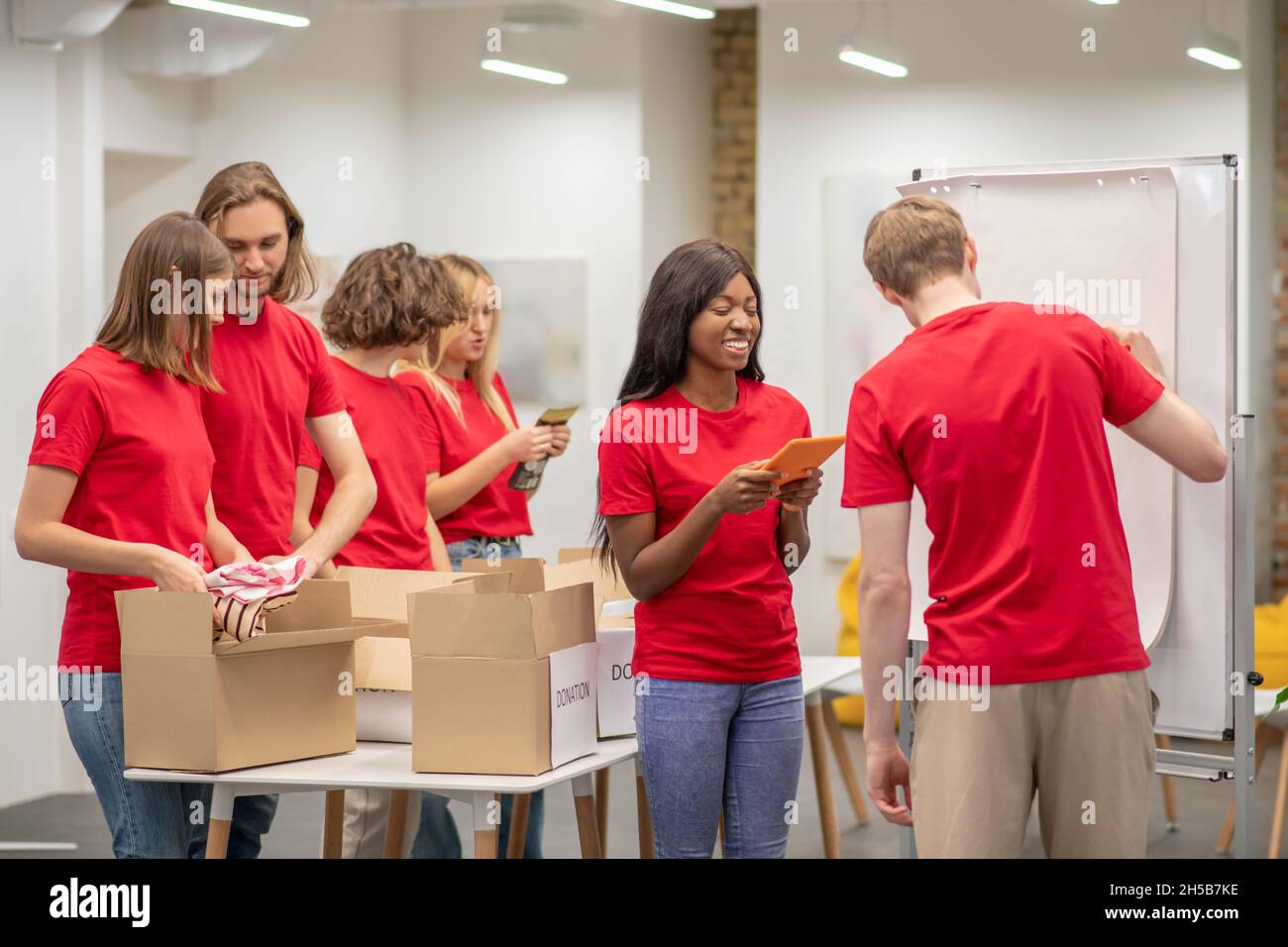 Young people in red looking busy while working with donations ...