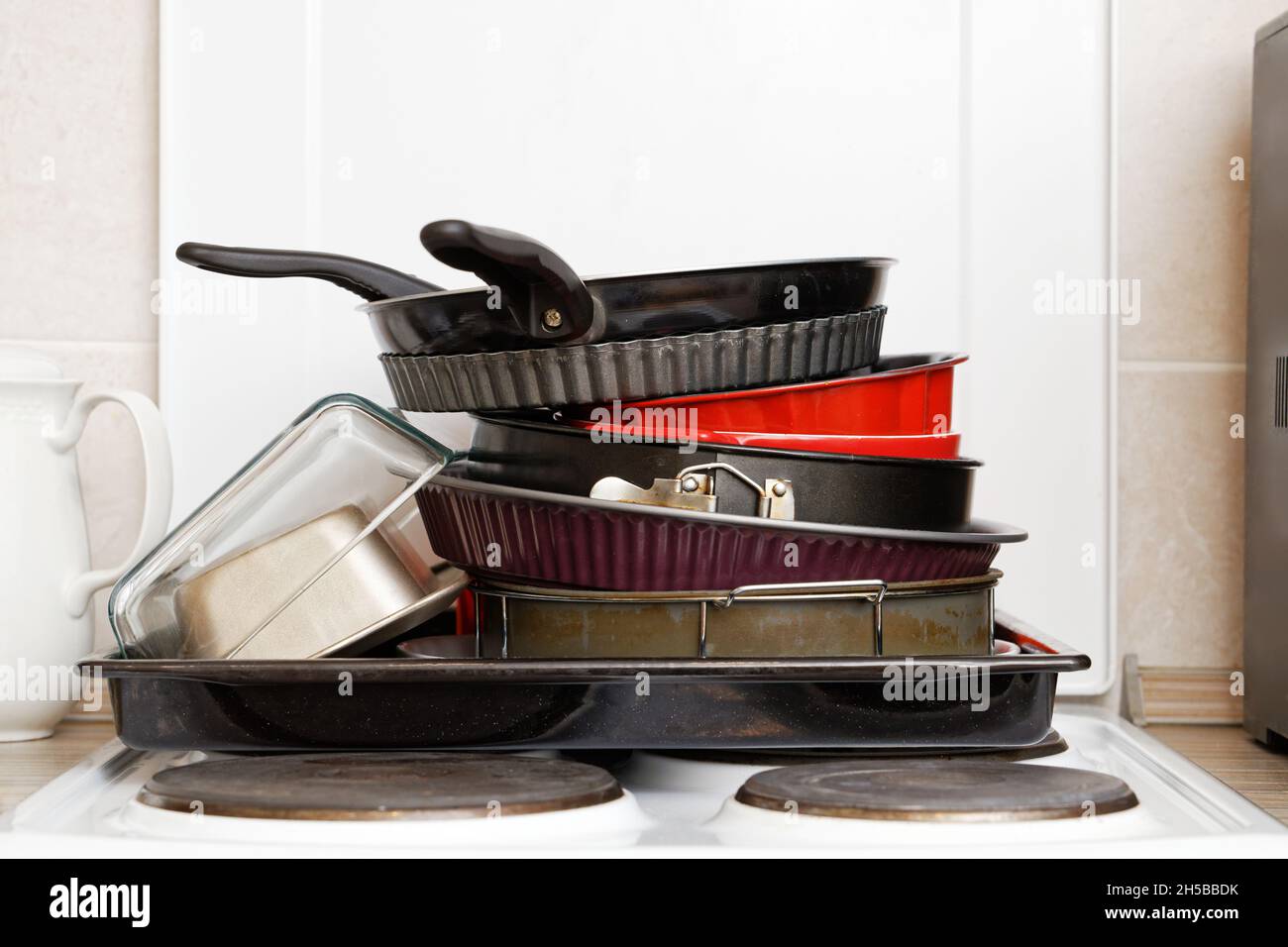 Set of cookware and pans stacked together on kitchen stove Stock Photo ...