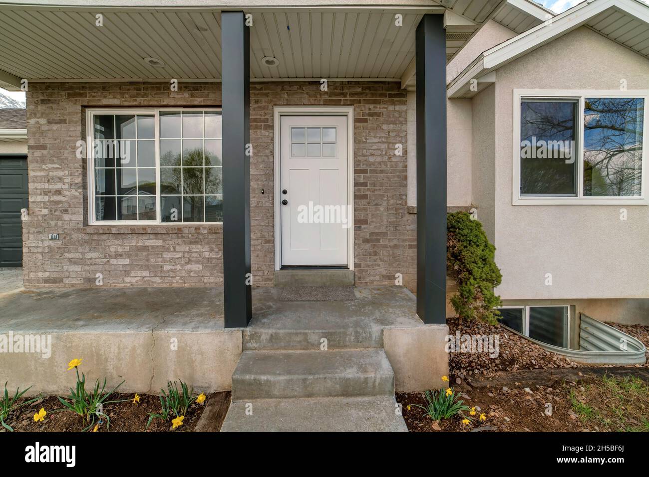 Porch of a house with black column posts and white front door with ...