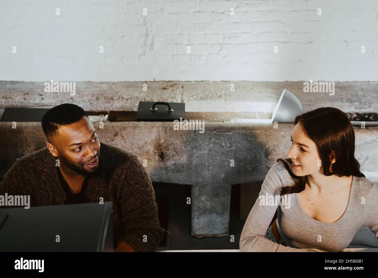 Female And Male Programmers Talking While Working On Computer In