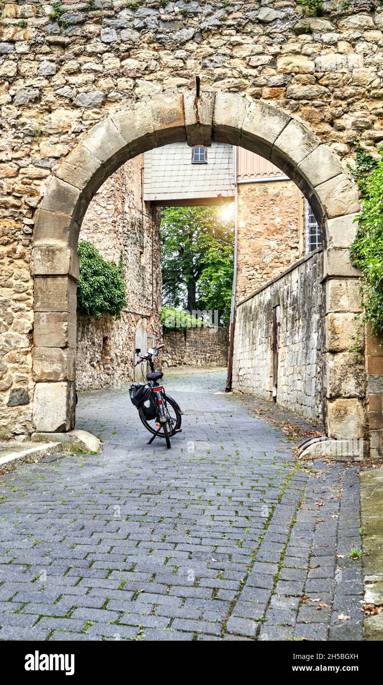 Bicycle stands in the arched gate made of natural stone, which connects ...