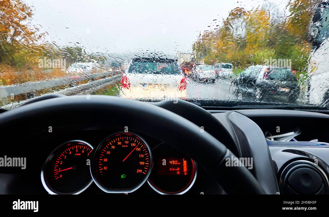 View over the dashboard of a car through the rain-dampened windshield ...