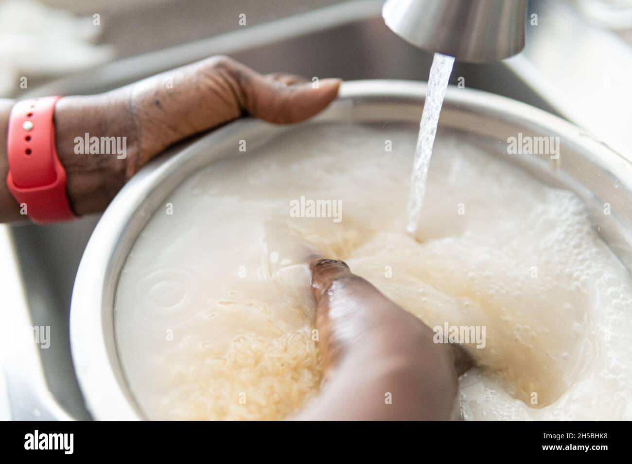 African American Nigerian woman washing rice before cooking Stock Photo ...