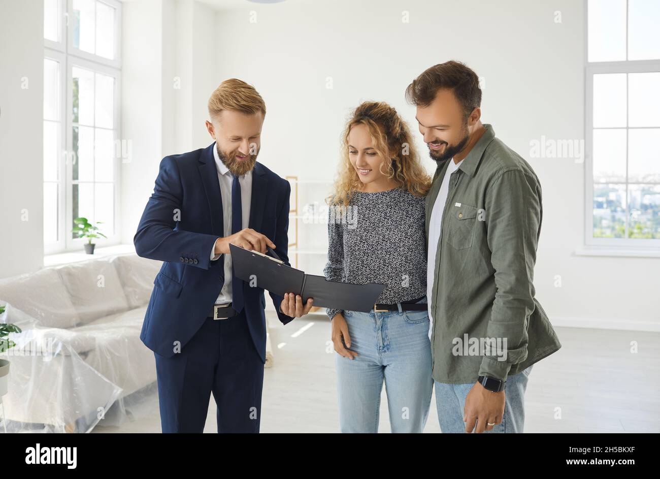Couple who are buying a new house meet with their real estate agent and ...