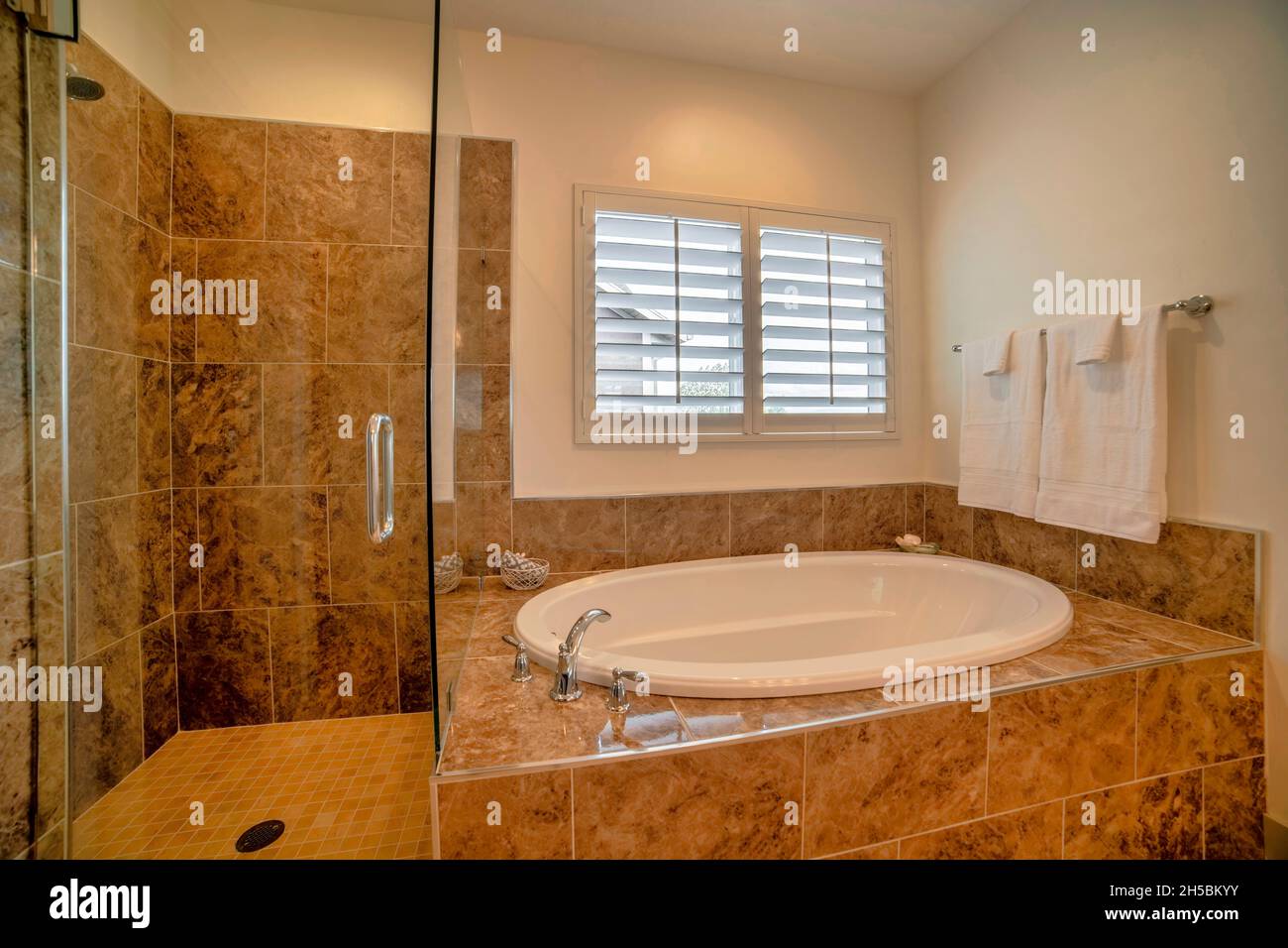 Bathroom interior with brilliant tan tiles and window Stock Photo - Alamy