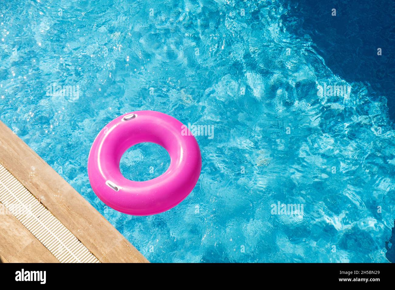 Pink inflatable ring in the swimming pool. Refreshing blue water. Top ...