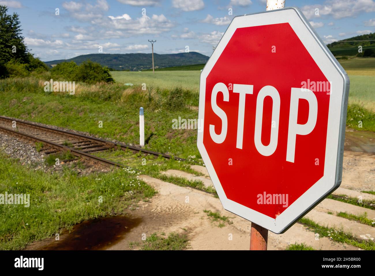 A red STOP sign before crossing the tracks Stock Photo - Alamy