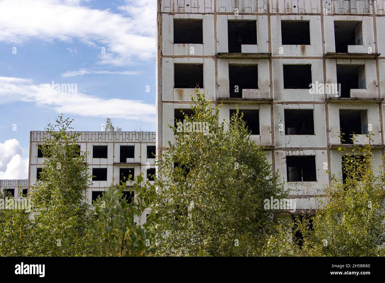 A damaged abandoned panel houses with decorative facade of small white ...