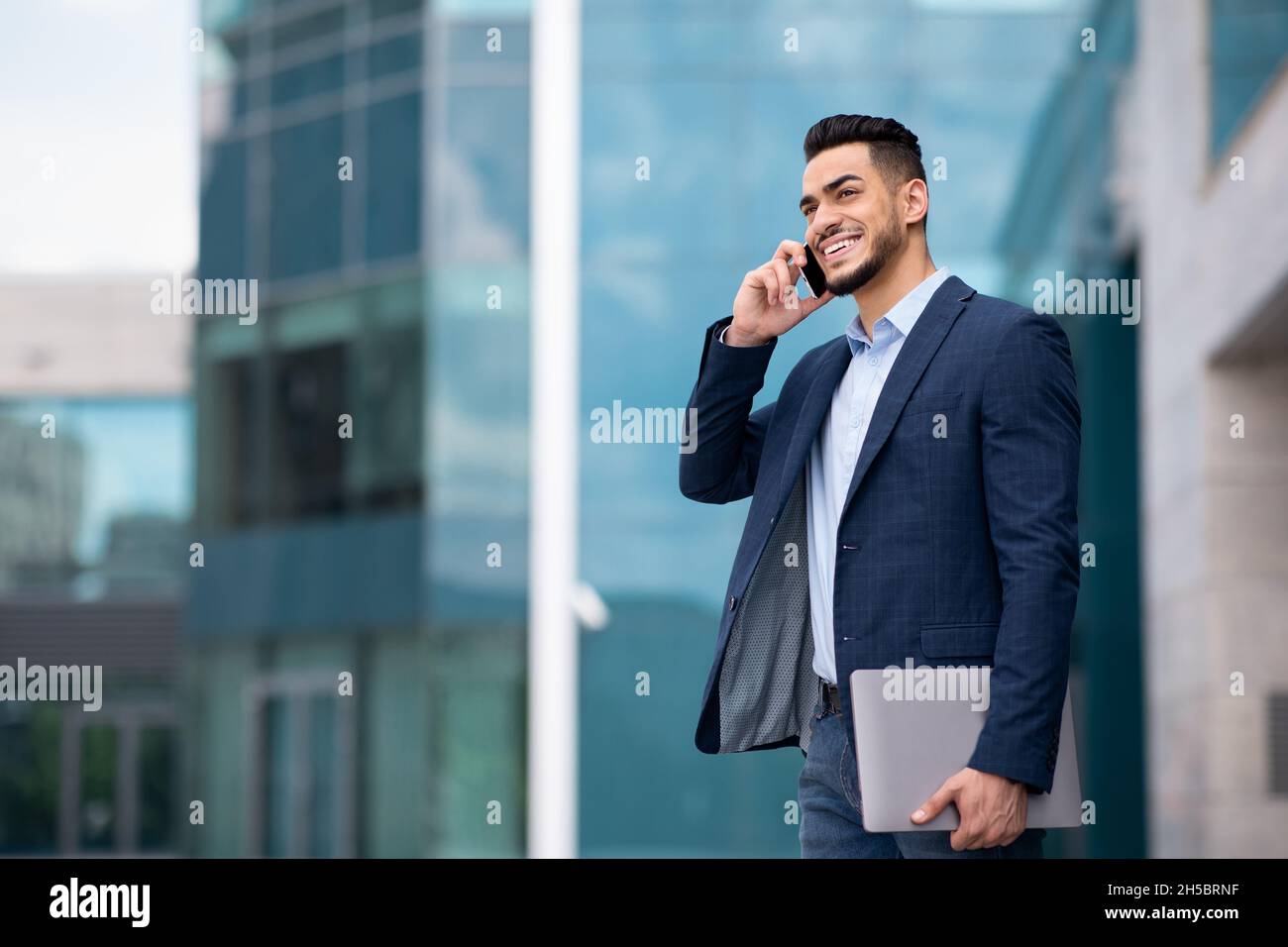 Happy middle eastern young entrepreneur having phone conversation Stock ...