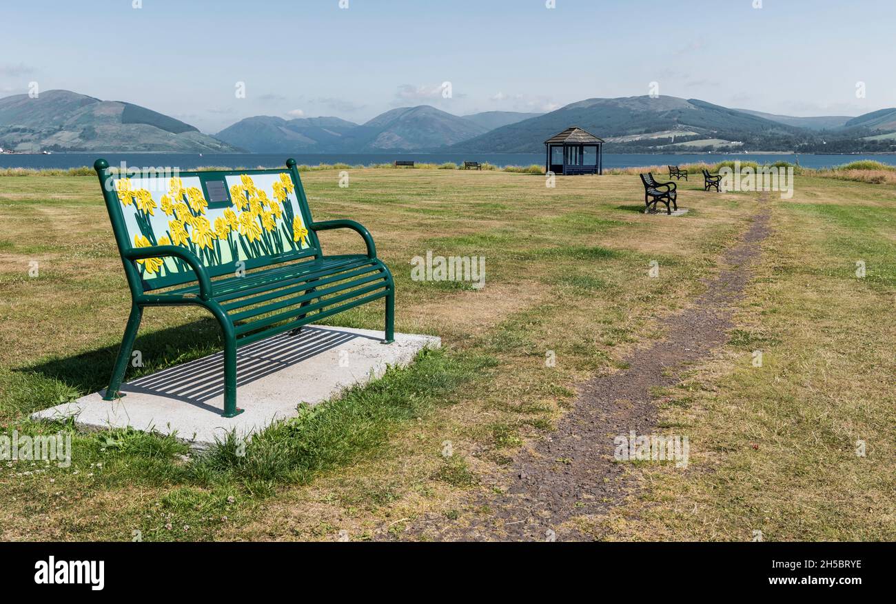 Outdoor public seats on green open space on the coast at Ardbeg Point ...