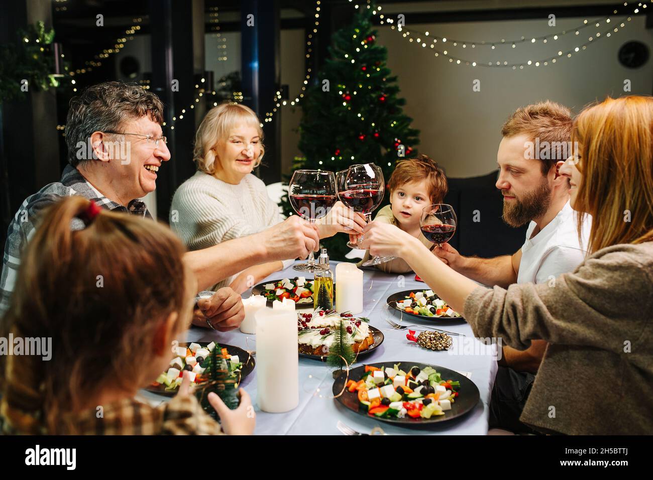 Lively big family on christmas gathering. Sitting around a big dining ...