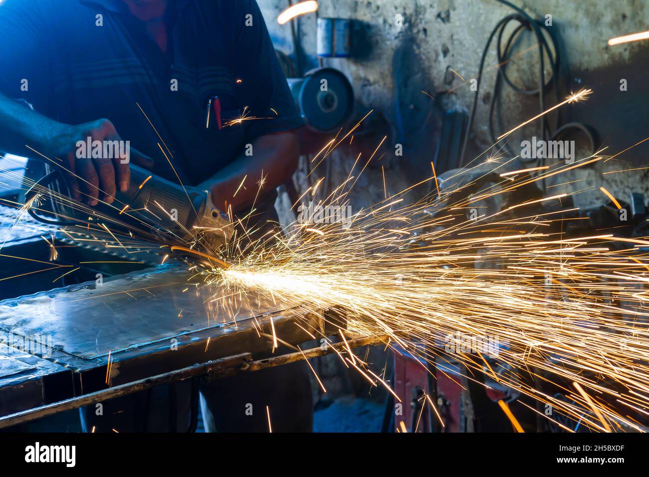 Metal worker using a grinder Stock Photo - Alamy
