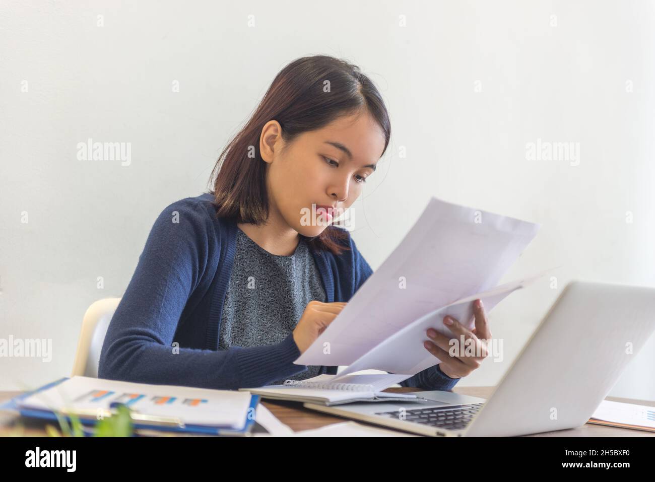 Asian manager reading the sales reports Stock Photo - Alamy