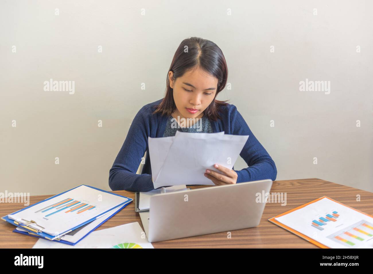 Office employee reading and checking reports Stock Photo - Alamy