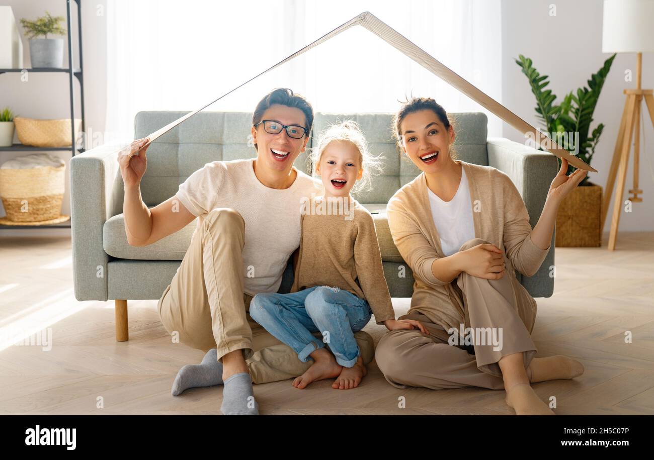 Mother, father and child girl in the room with a symbol of roof ...