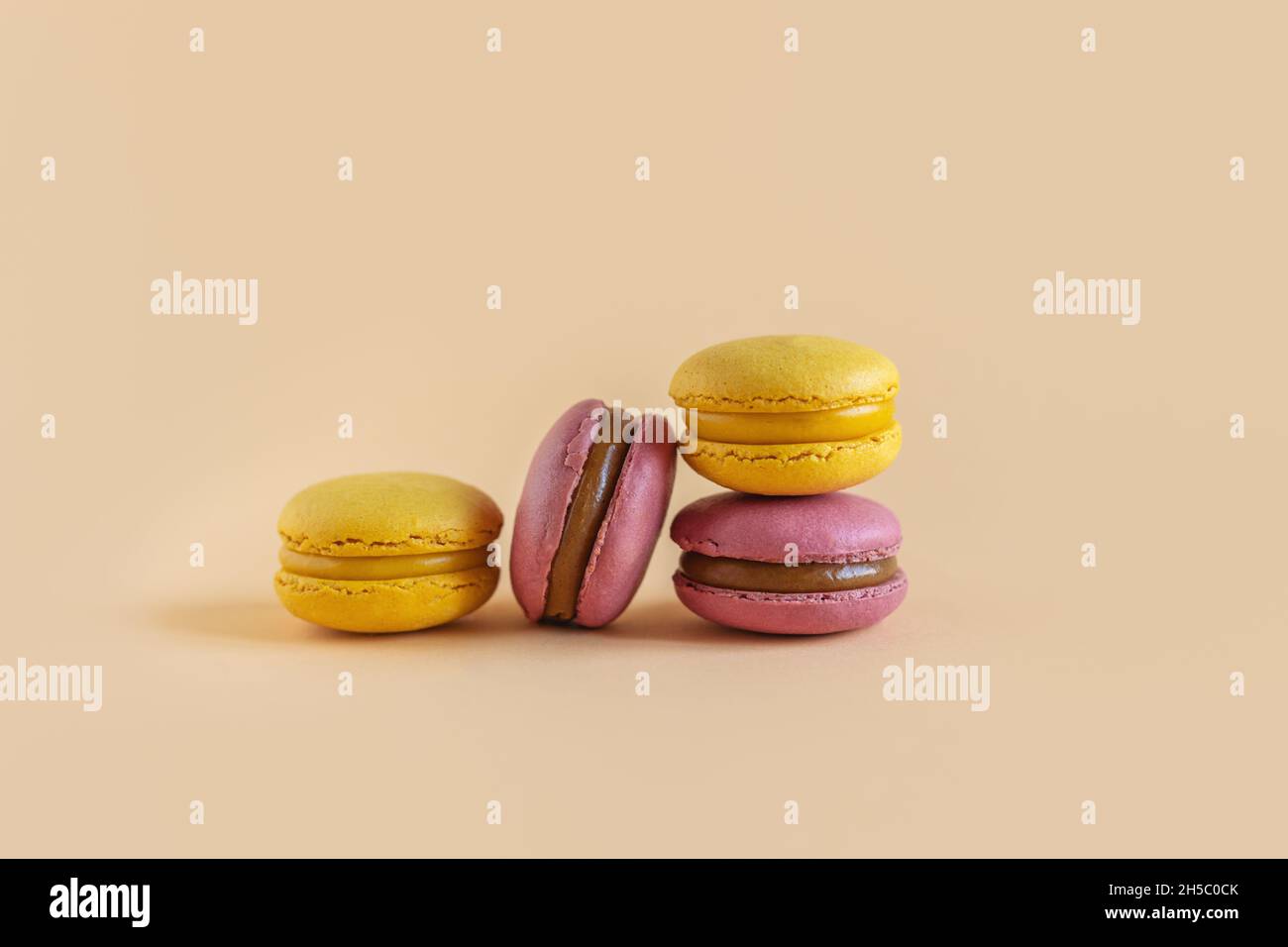 Tasty french macarons on a yellow pastel background. Place for text ...