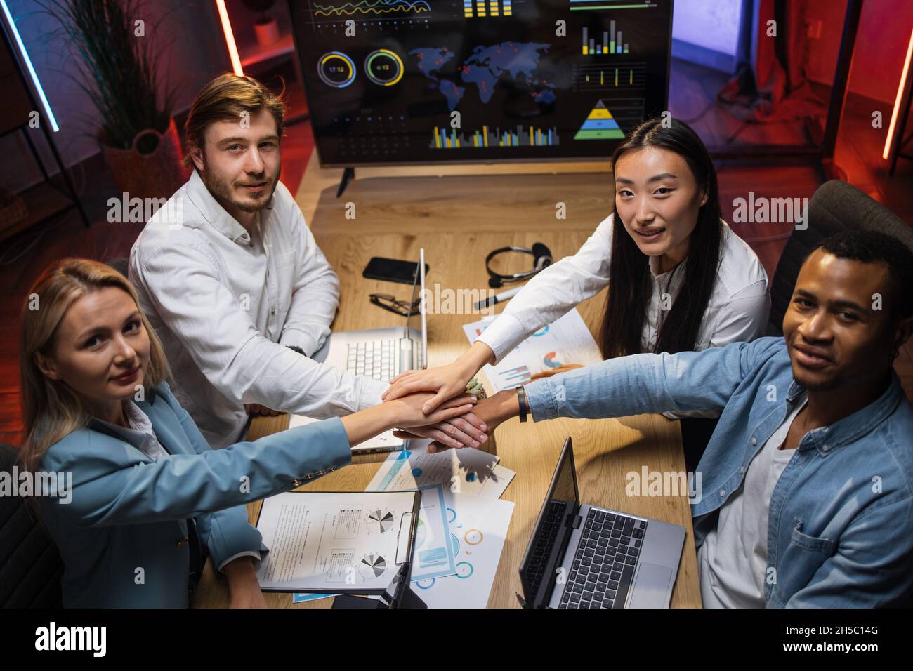 Top view of multiracial business people stacking their hands together ...