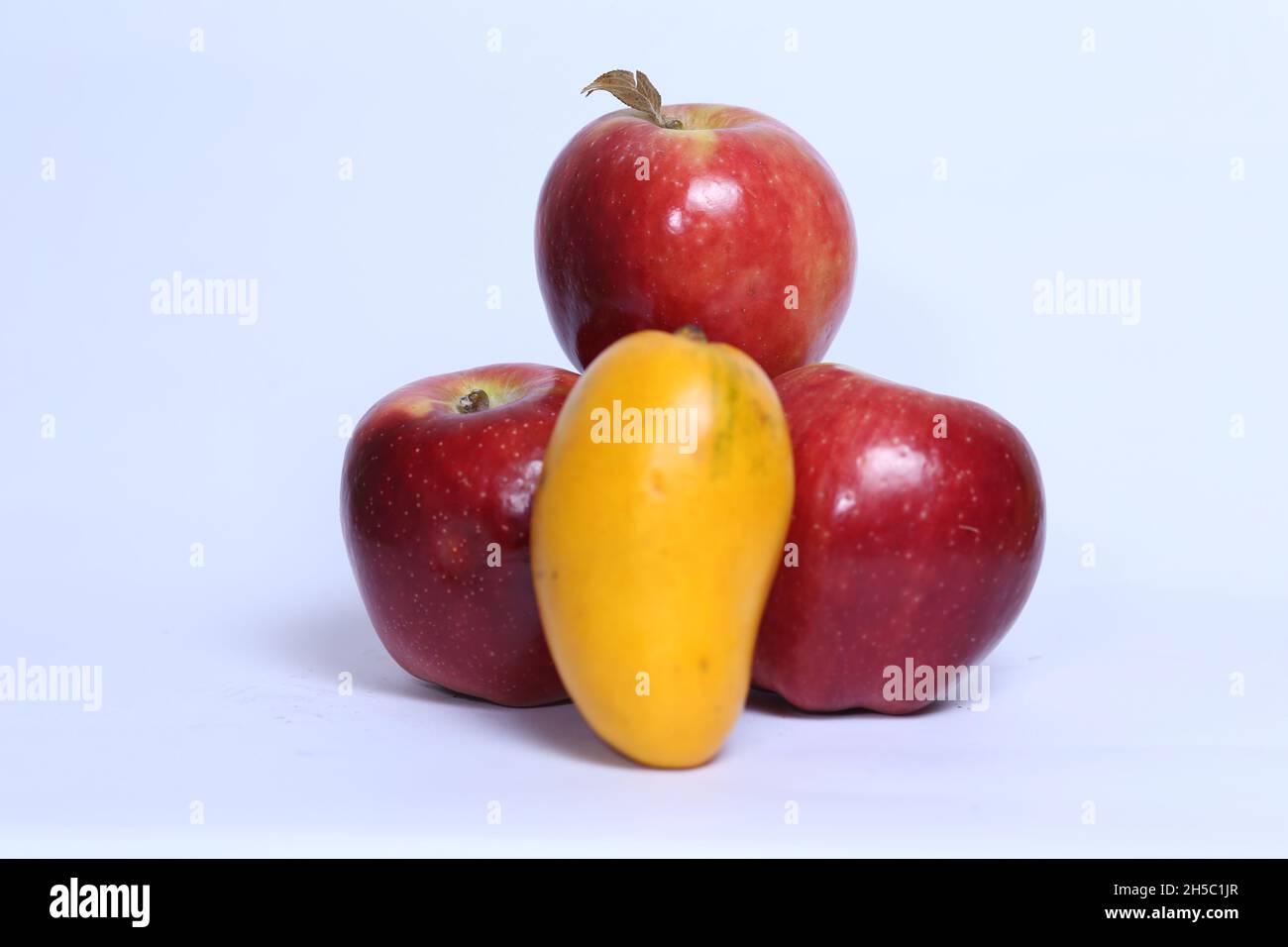 Red apples and a mango isolated on white background Stock Photo - Alamy