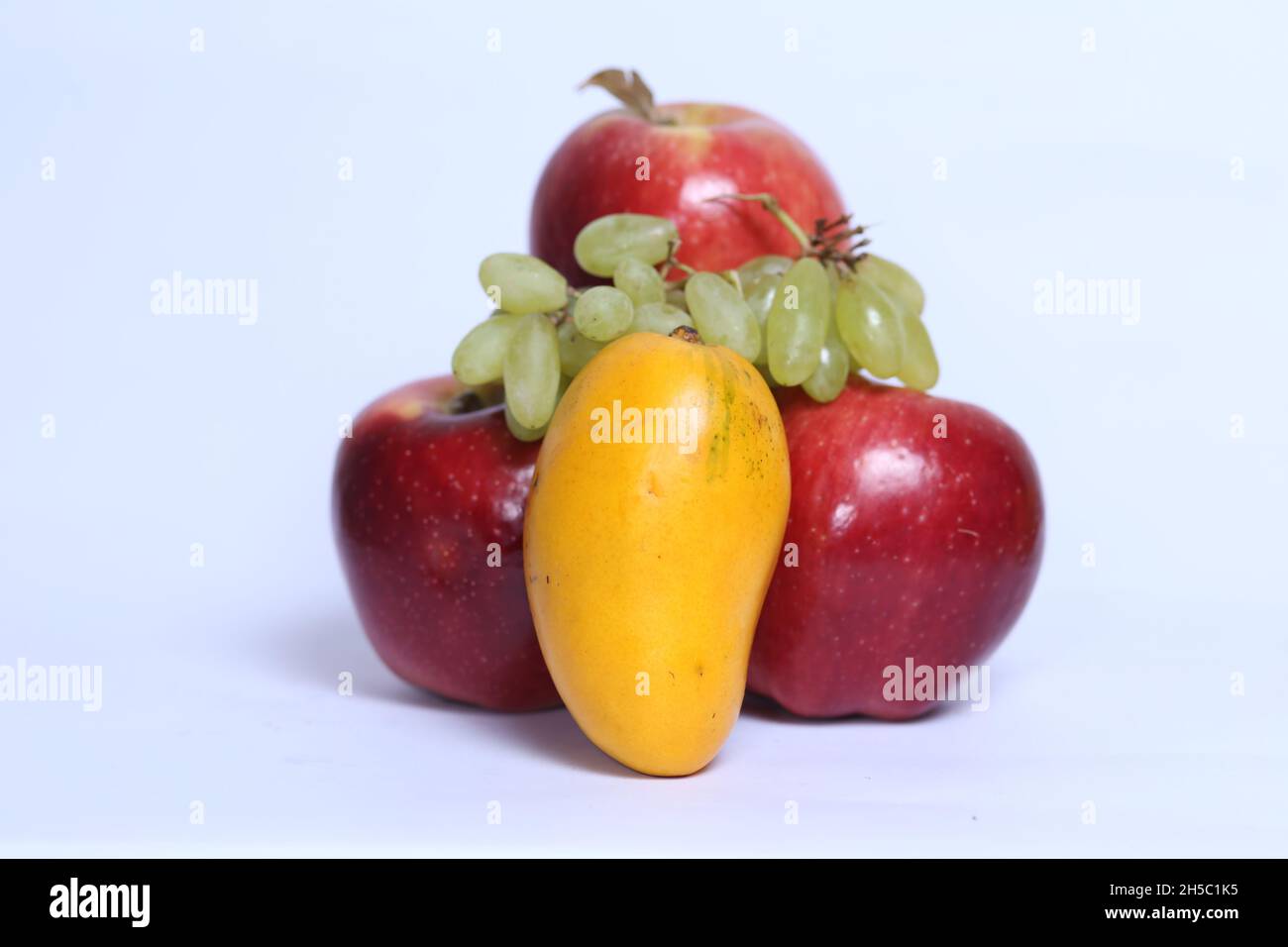 Red apples, a mango and grapes isolated on white background Stock Photo ...