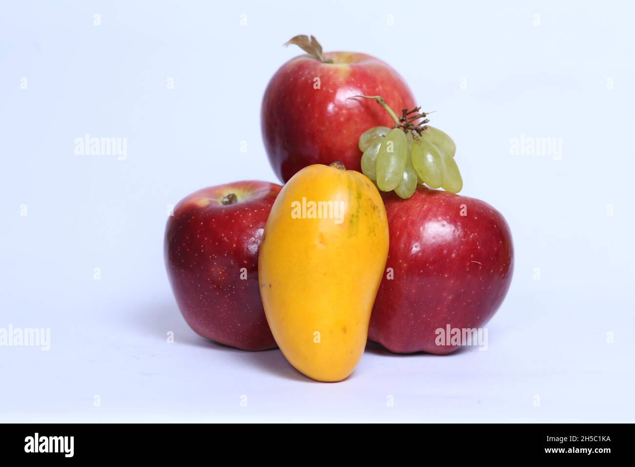 Red apples, mango and grapes isolated on white background Stock Photo ...