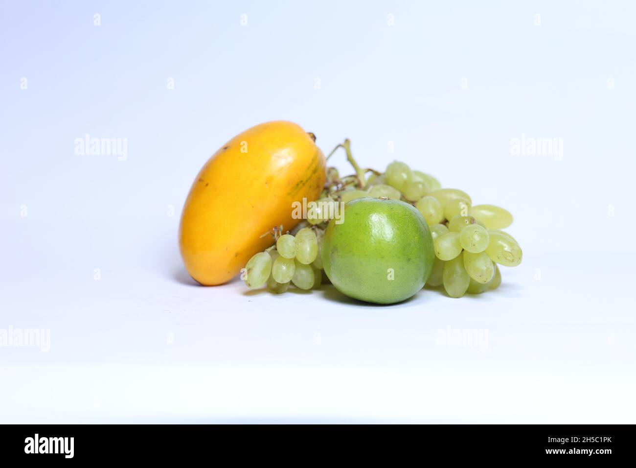 Citrus limetta, grapes and mango isolated on white background Stock ...
