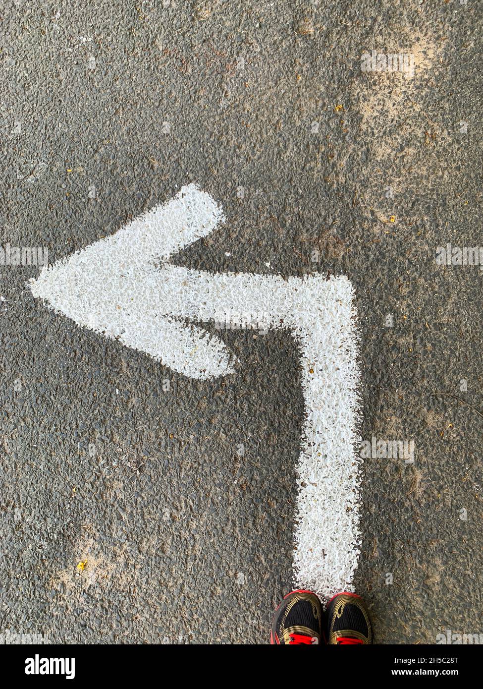 Runner standing on road by a left turn arrow, New Delhi, India Stock ...