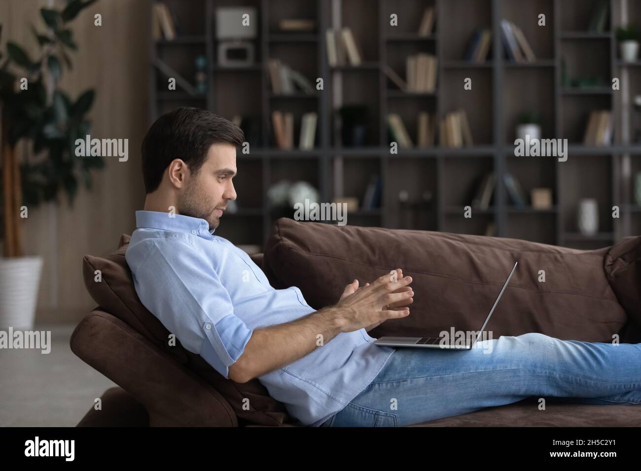 Relaxed young man holding video call conversation Stock Photo - Alamy