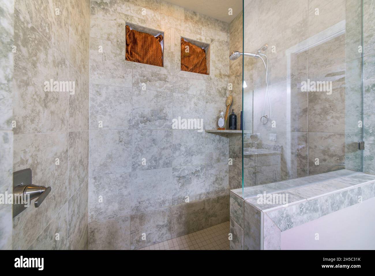 Shower stall with gray marble tiles and glass wall panel Stock Photo ...