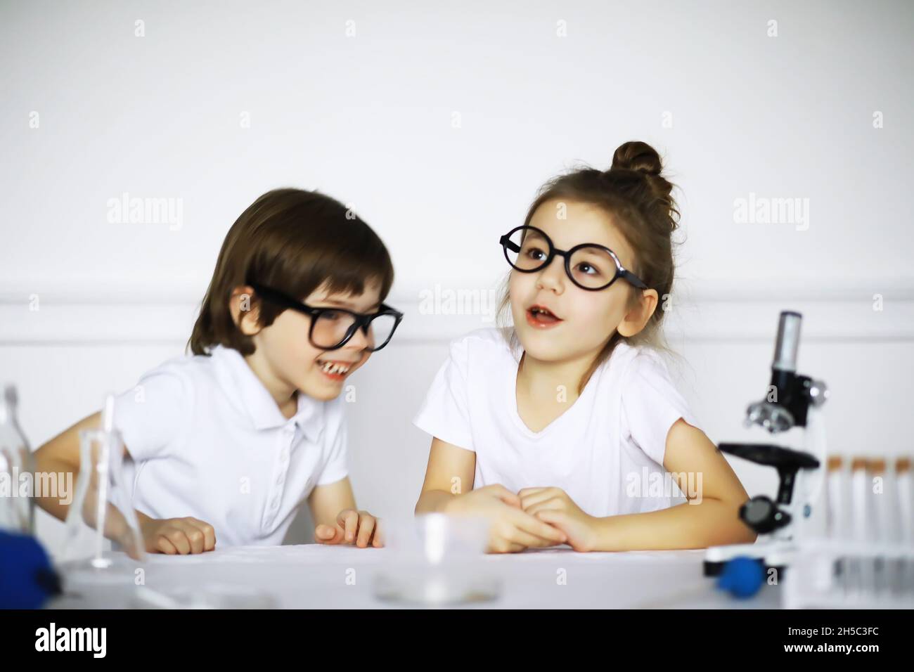 Two cute children at chemistry lesson making experiments isolated on ...