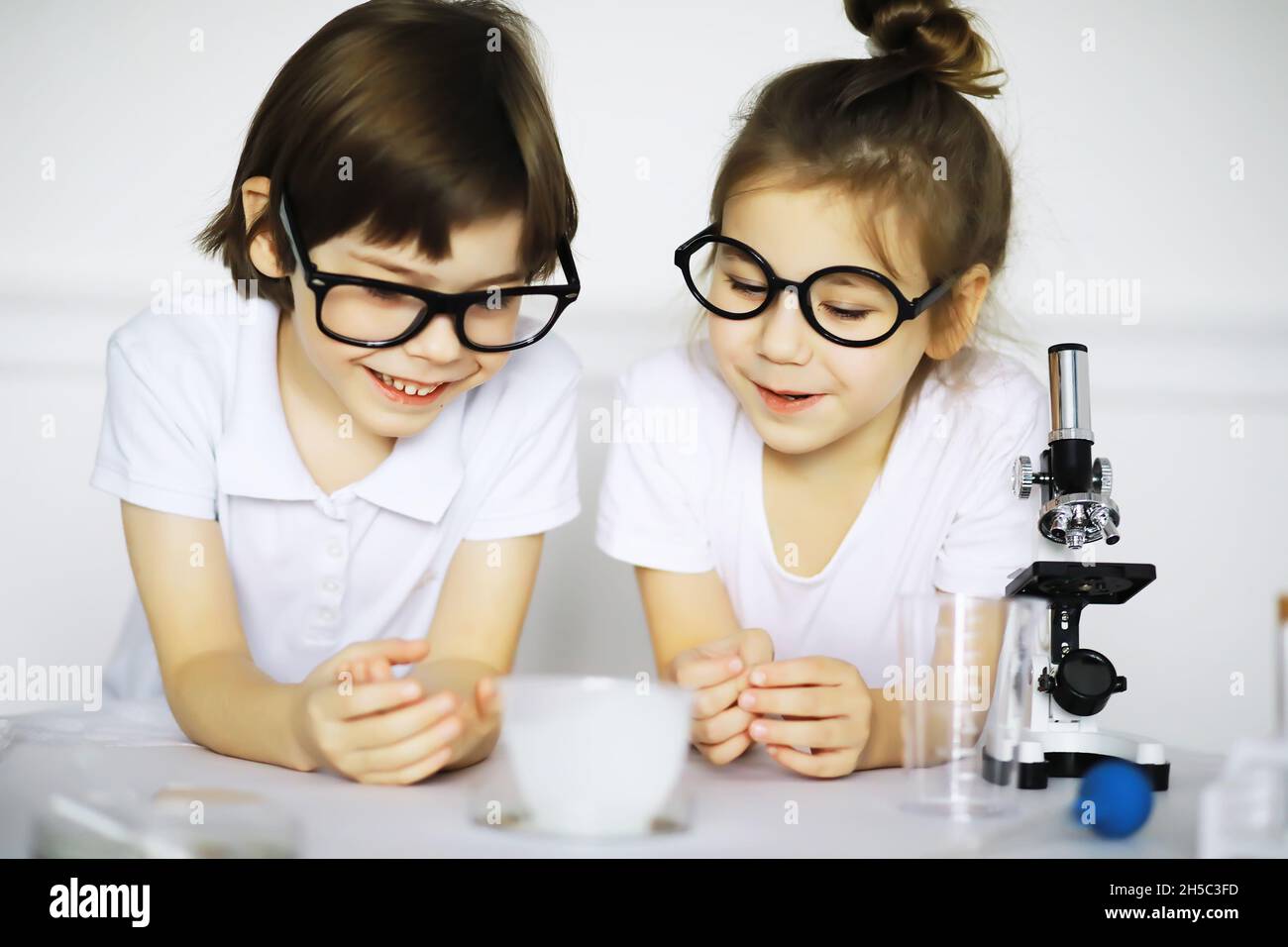Two cute children at chemistry lesson making experiments isolated on ...