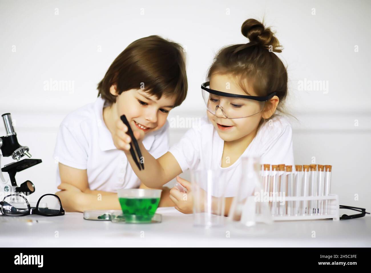 Two cute children at chemistry lesson making experiments isolated on ...