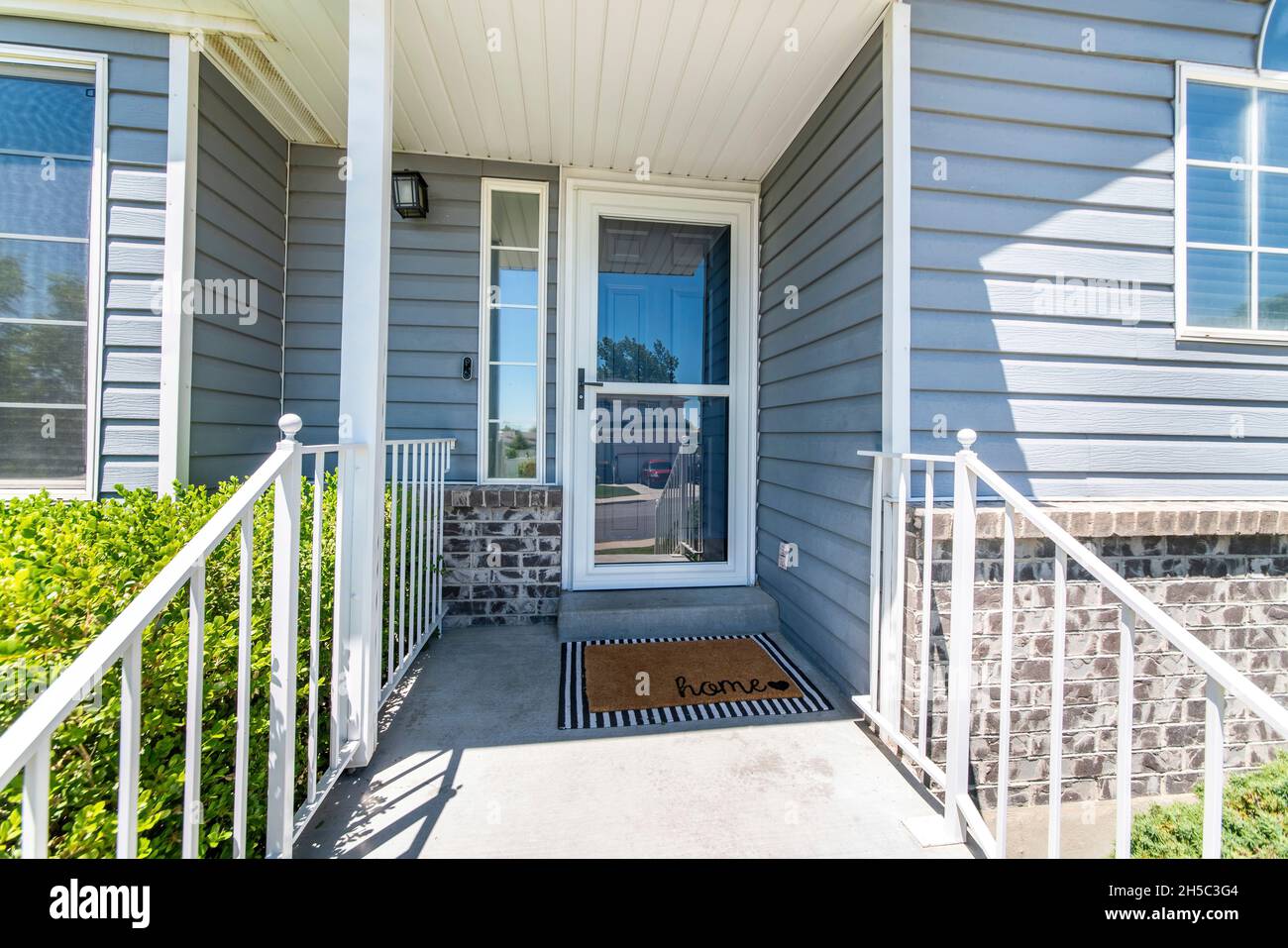 Front porch of a house with glass storm door with sidelight Stock Photo ...