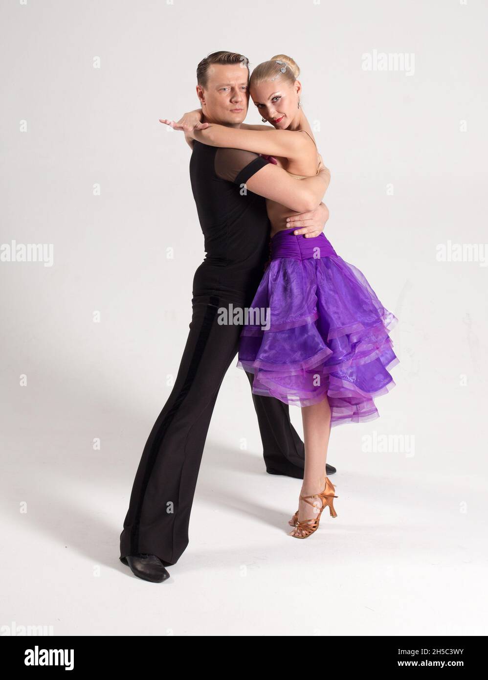 Dancing young couple on a white background purple dress Stock Photo - Alamy