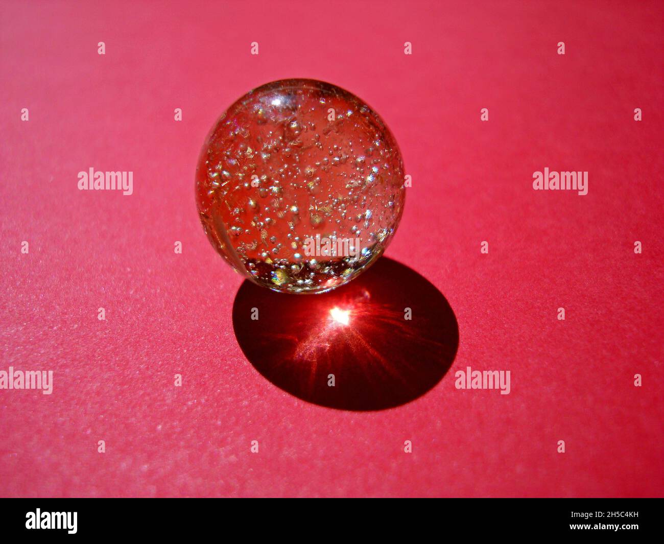 Marble ball on red background Stock Photo - Alamy