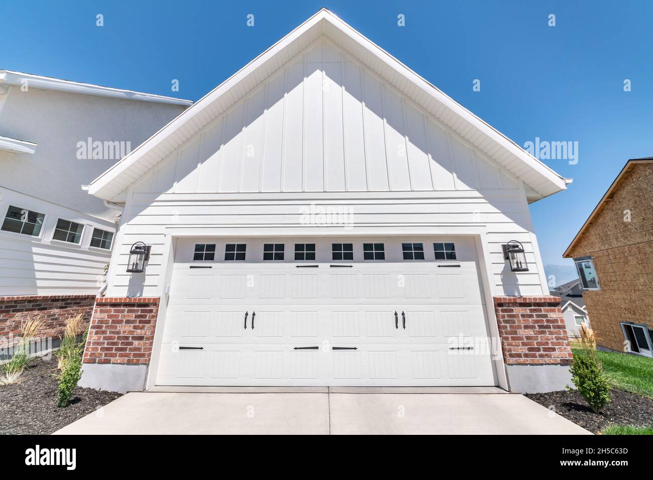Exterior of a garage with white wood and red bricks siding Stock Photo ...