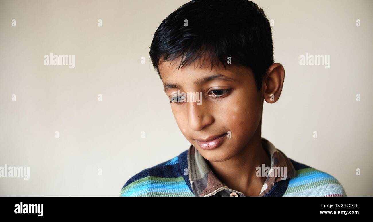 Closeup portrait of a South Asian kid smiling on a white background ...