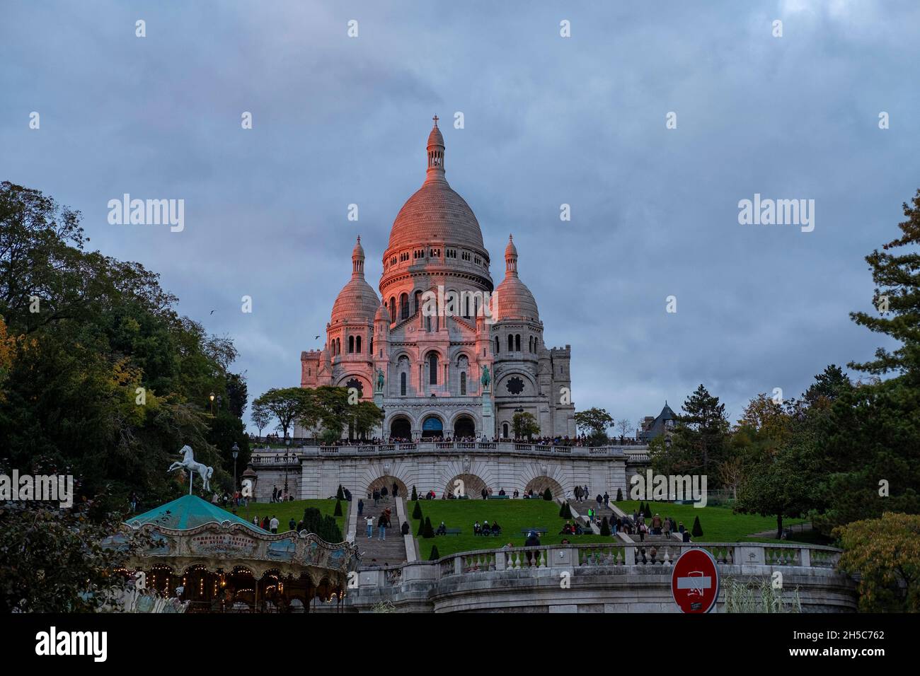 The sunset lights up the Sacre-Coeur basilica at the summit of the ...