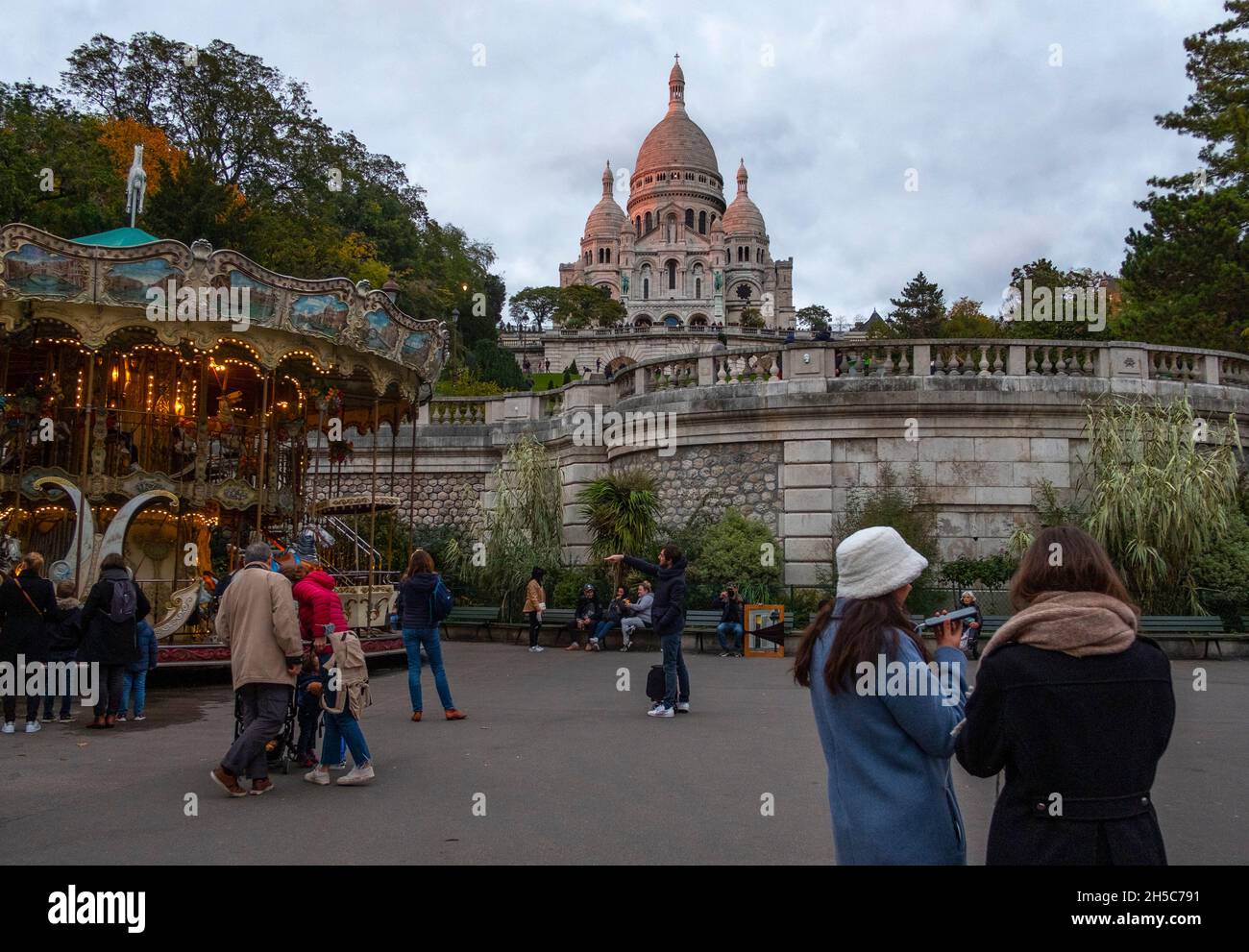The sunset lights up the Sacre-Coeur basilica at the summit of the ...