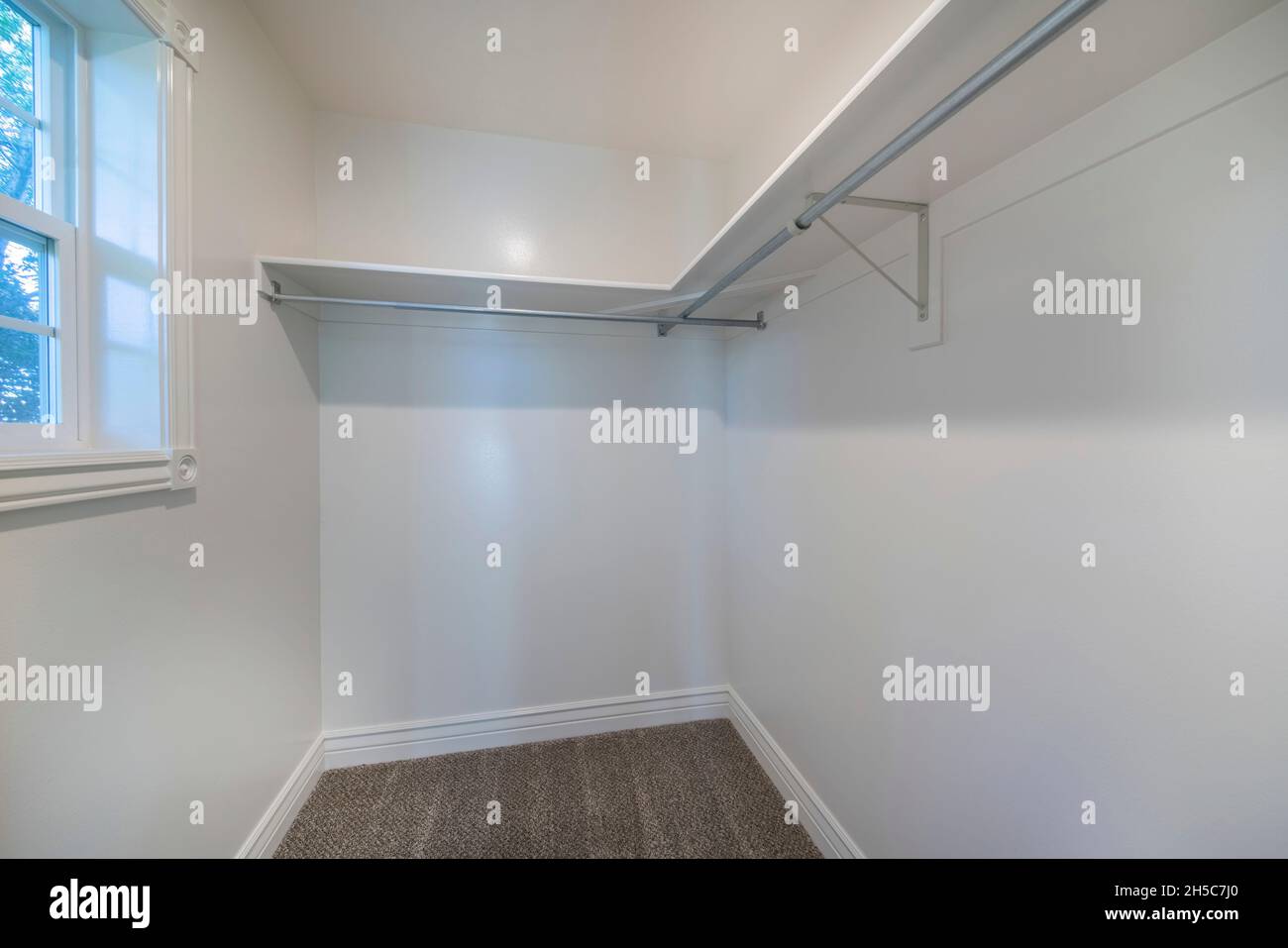 Small empty walk in closet with white interior and window Stock Photo ...