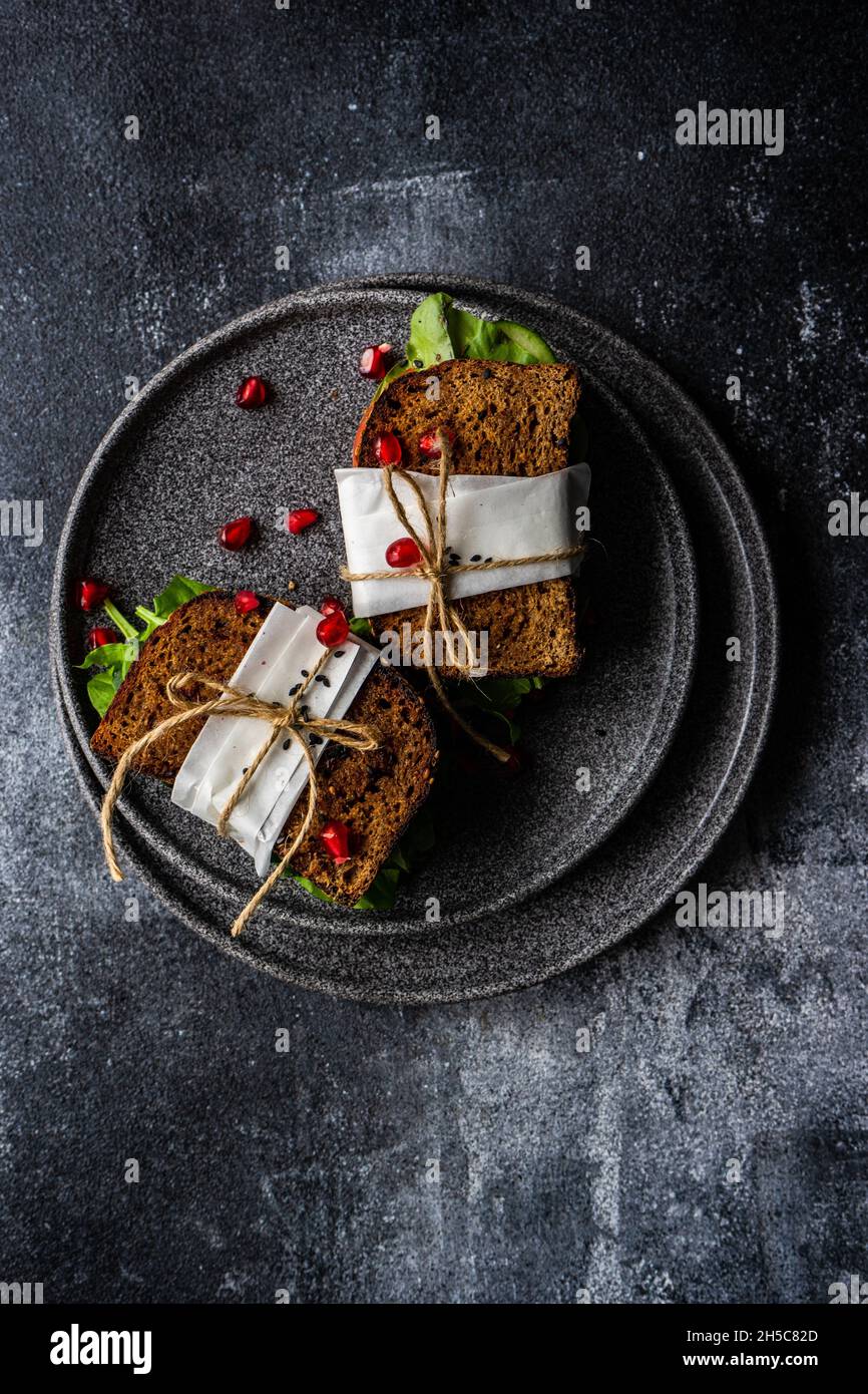 Overhead view of a salad sandwich wrapped in paper and tied with string ...