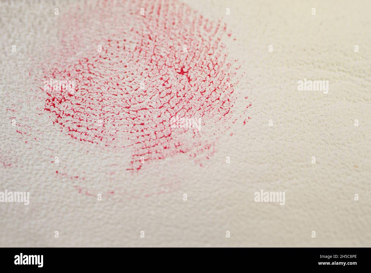 Selective focus macro of a bloody fingerprint on fake white leather ...