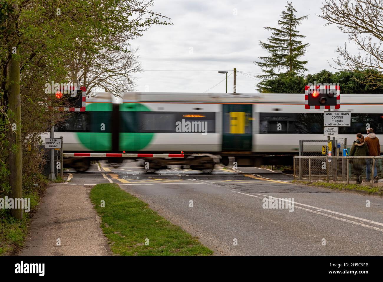southern rail train passing over an automatic half barrier level ... southern rail train passing over an automatic half barrier level ...