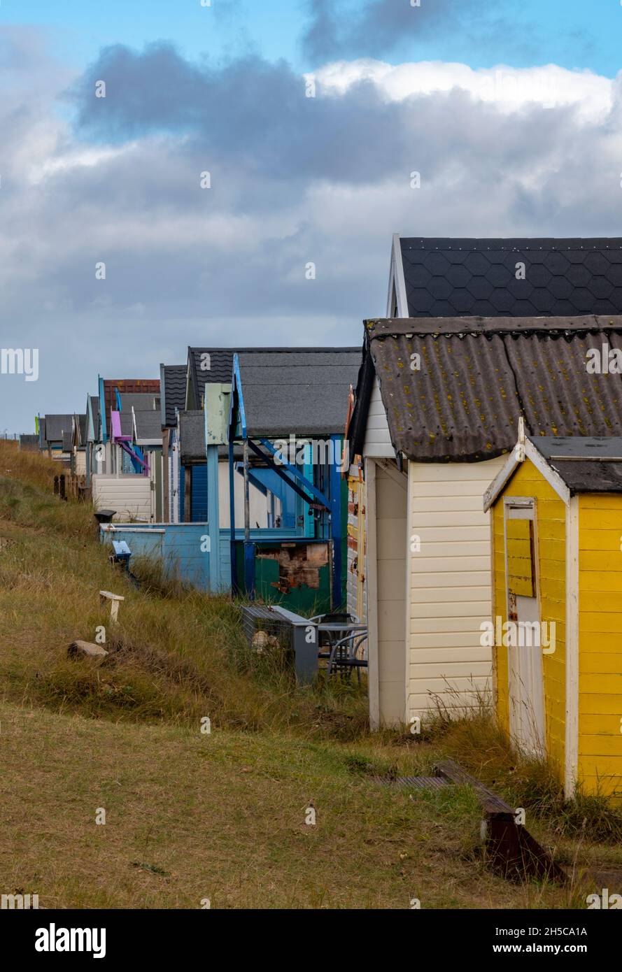 row of beach huts at heacham on the north norfolk coast, atmospheric ...