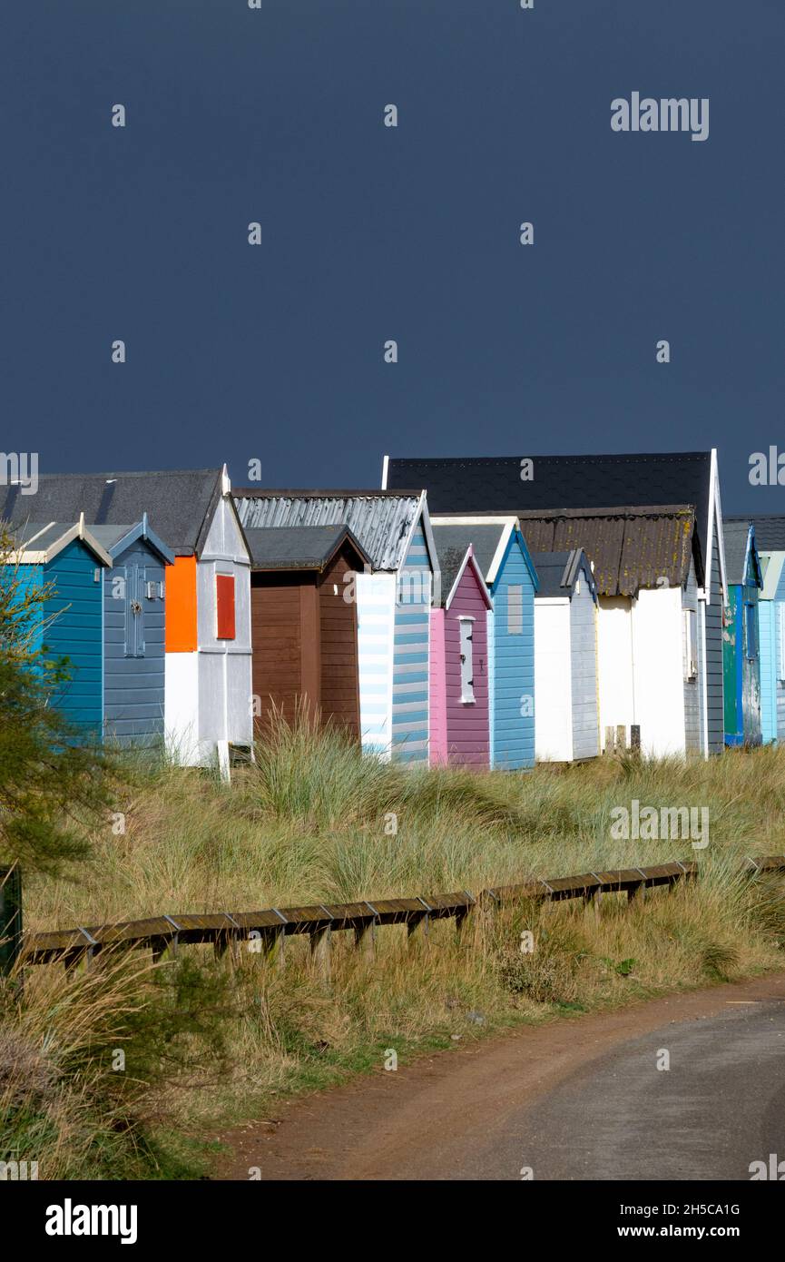 row of colourful painted beach huts and chalets on the north norfolk ...
