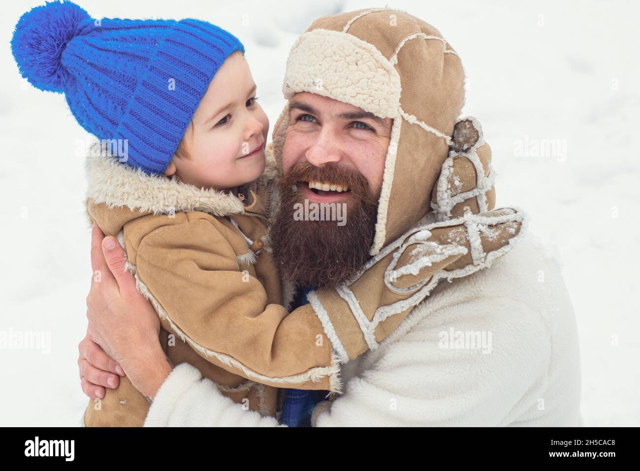 Winter, father and son play outdoor. Daddy and boy smiling and hugging ...